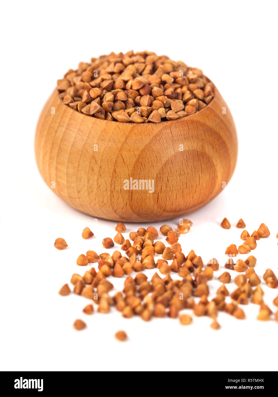 Roasted buckwheat grains in wooden bowl isolated on white background ...
