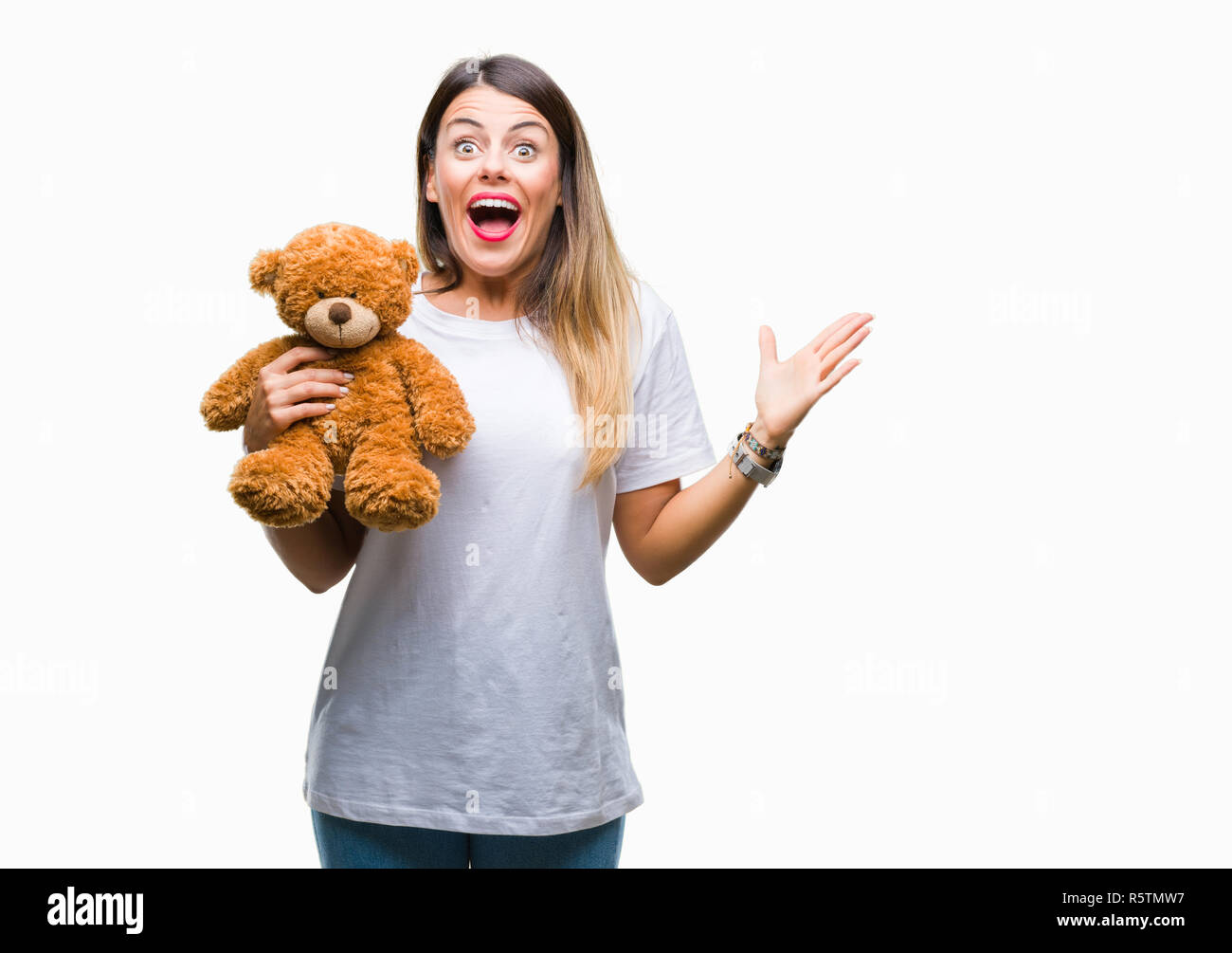 Young beautiful woman holding teddy bear plush over isolated background ...
