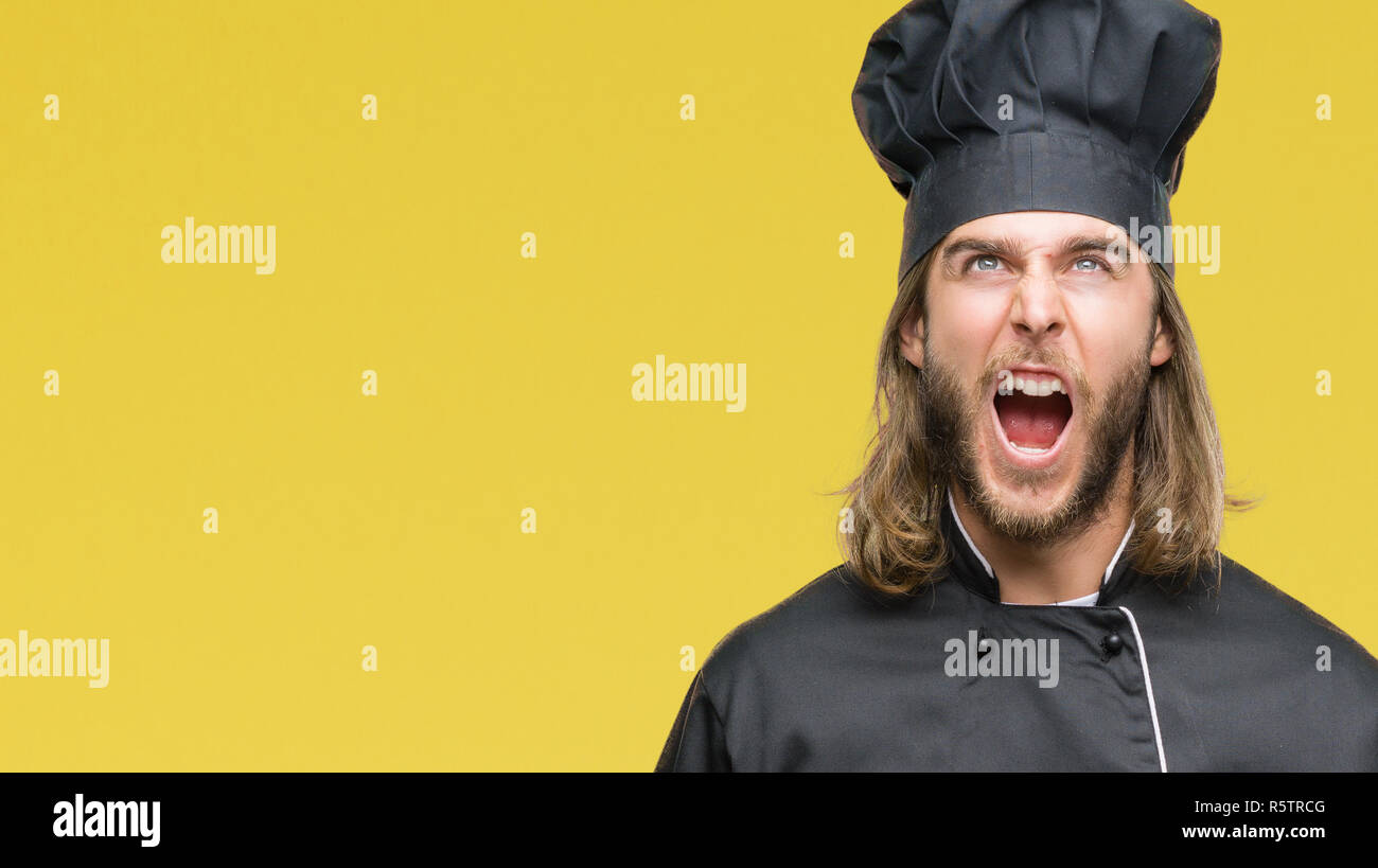 Young handsome cook man with long hair over isolated background crazy ...