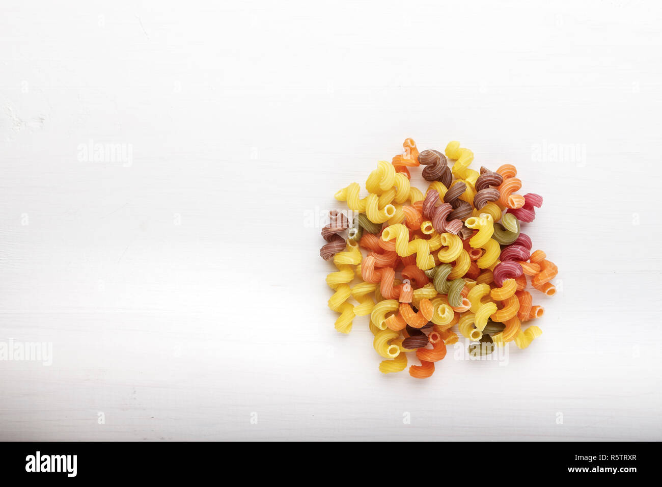 uncooked multi colored pasta isolated on white background. space for ...