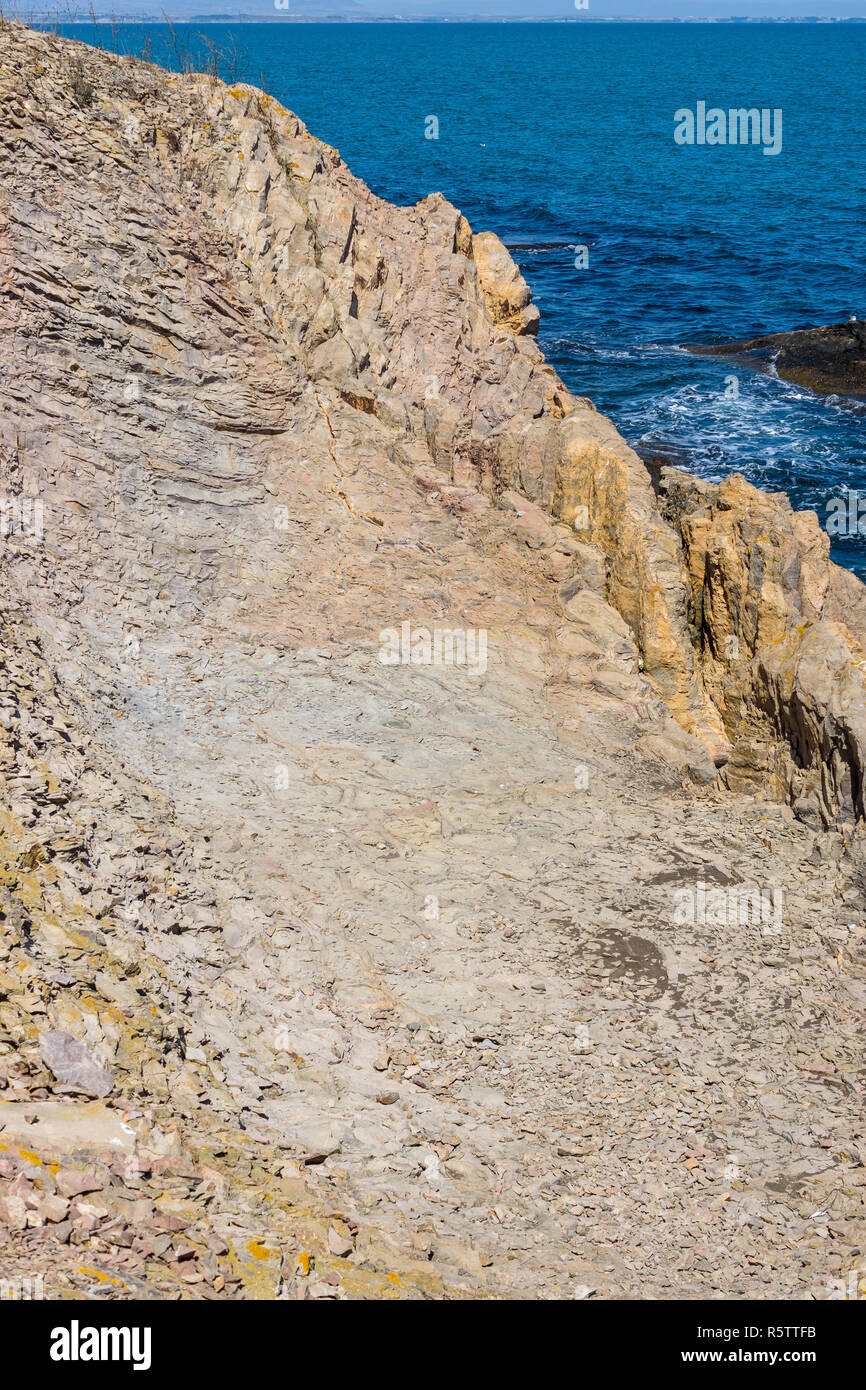 Sedimentary rocks and the blue sea Stock Photo - Alamy