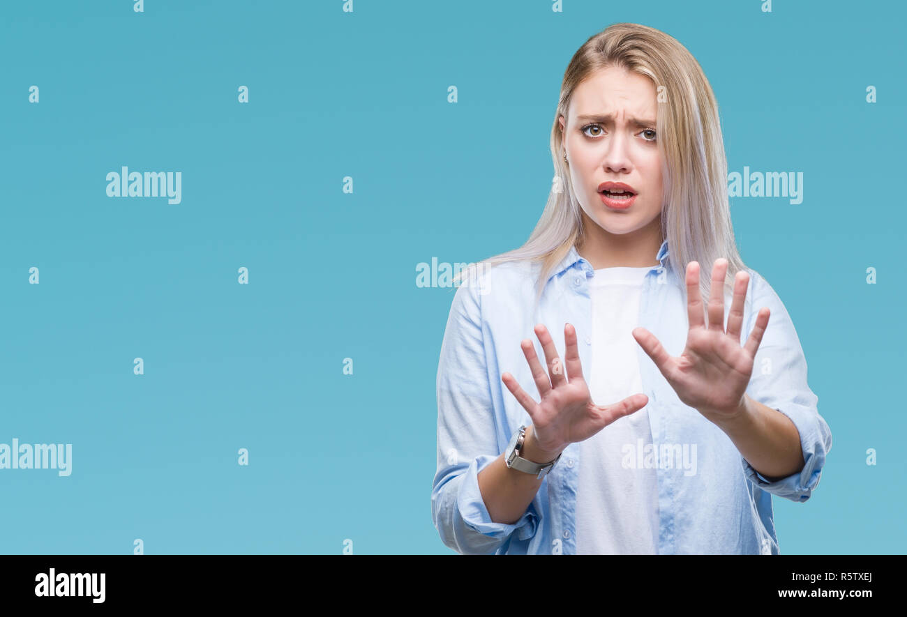 Young blonde woman over isolated background afraid and terrified with ...