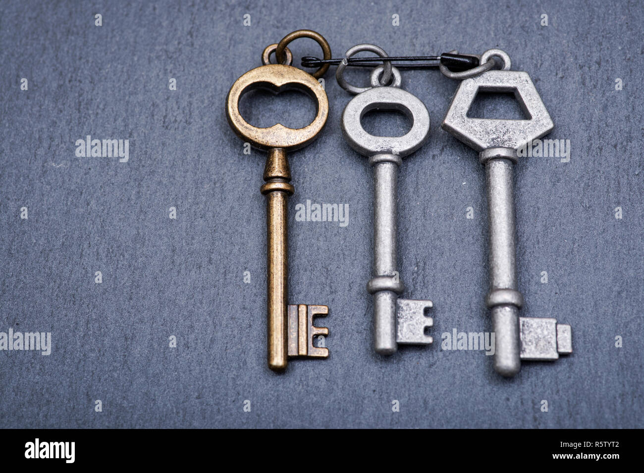 Old vintage metallic keys an natural stone background Stock Photo - Alamy