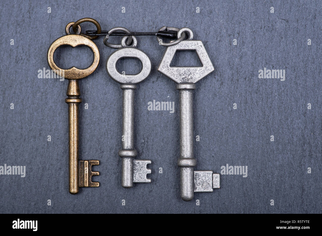 Old vintage metallic keys an natural stone background Stock Photo - Alamy