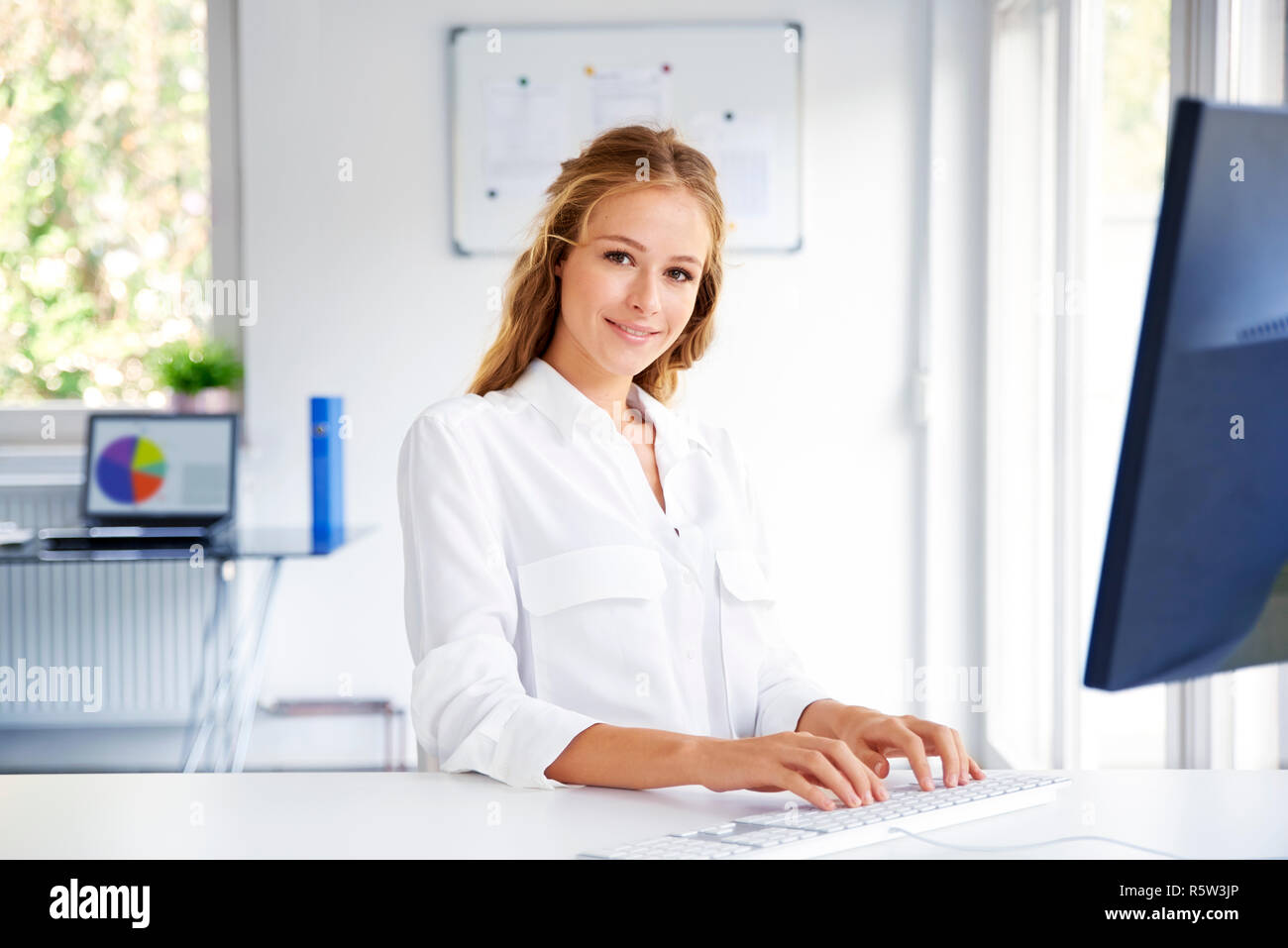 Shot of smiling young financial assistant professional woman typing on ...