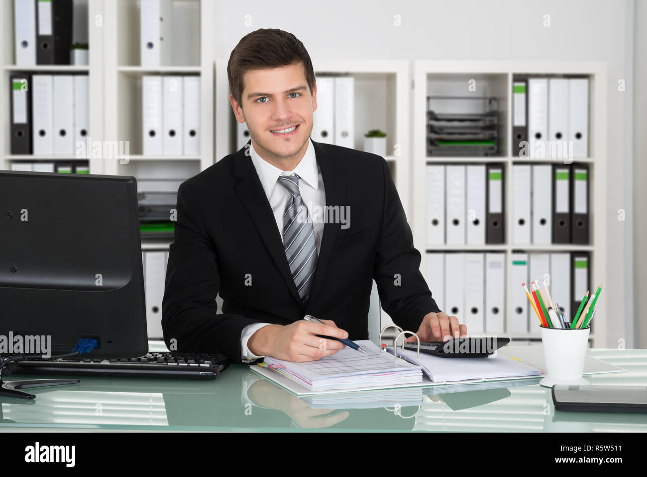 Happy Businessman Calculating Bill Stock Photo - Alamy