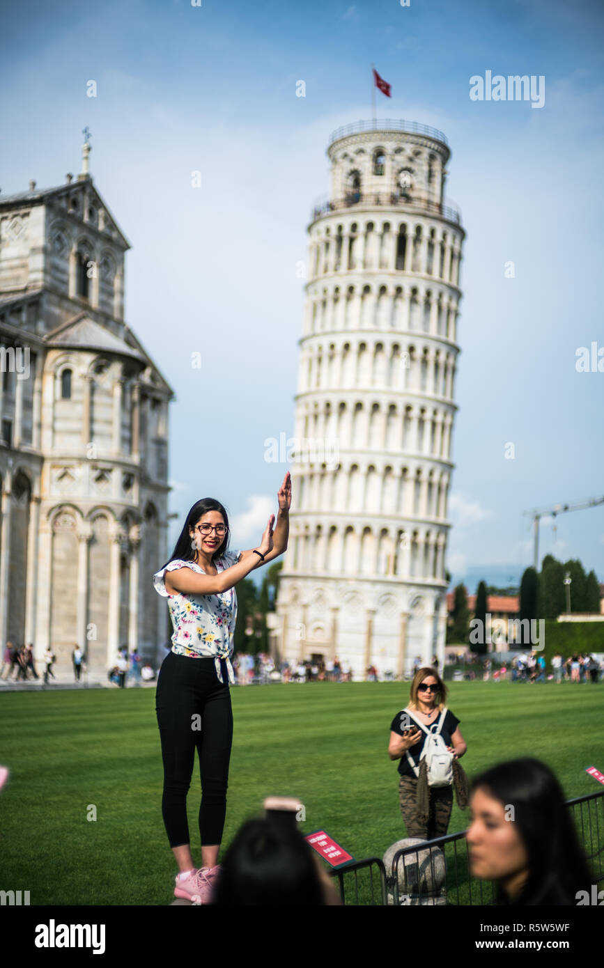 Tourists in front of Pisa tower make action pictures, Pisa, Italy ...