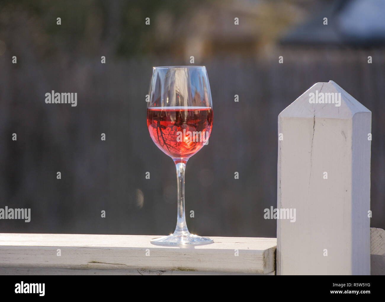 Glass of wine on a deck railing Stock Photo - Alamy
