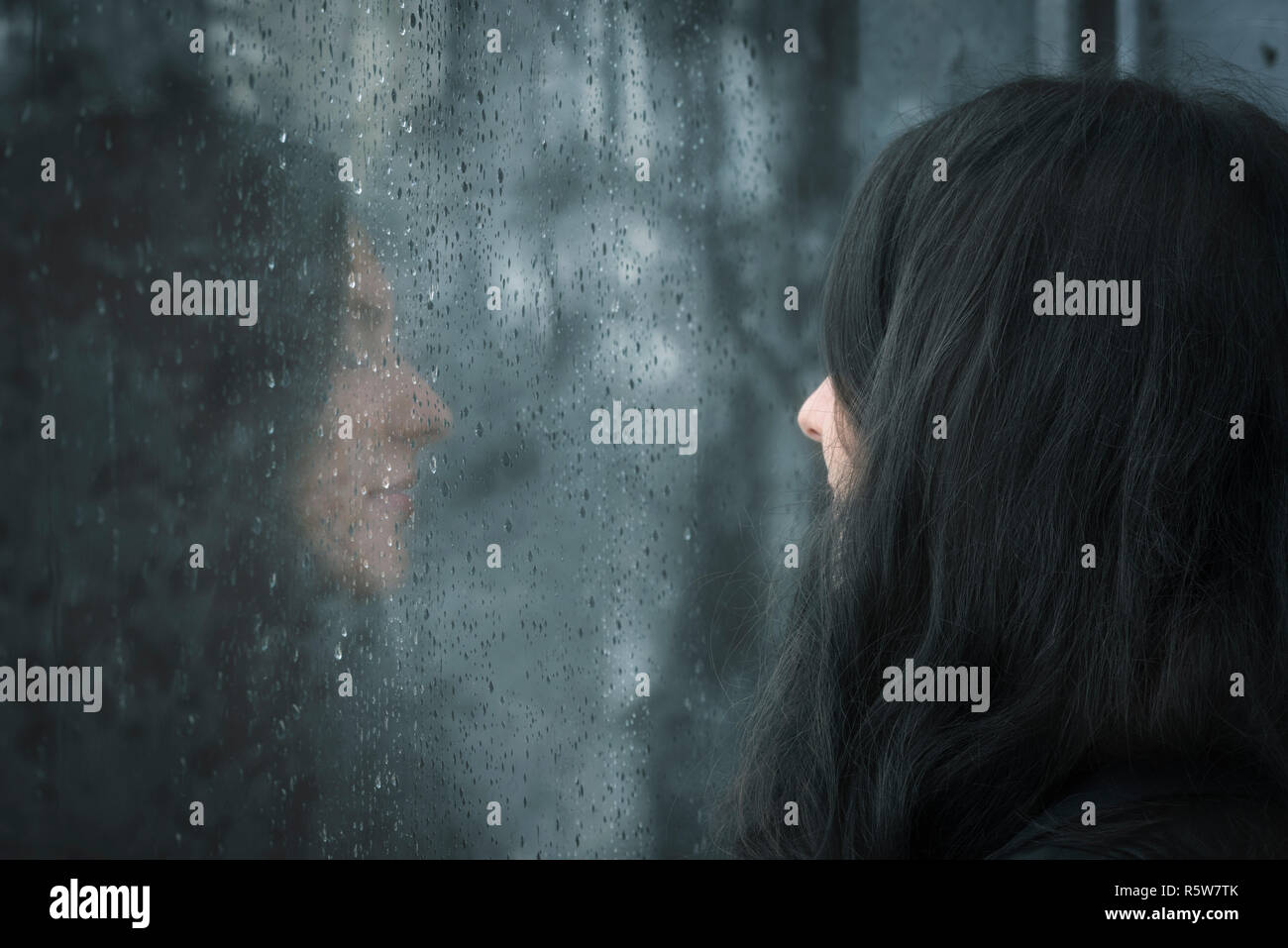 Woman in front of rainy window Stock Photo - Alamy
