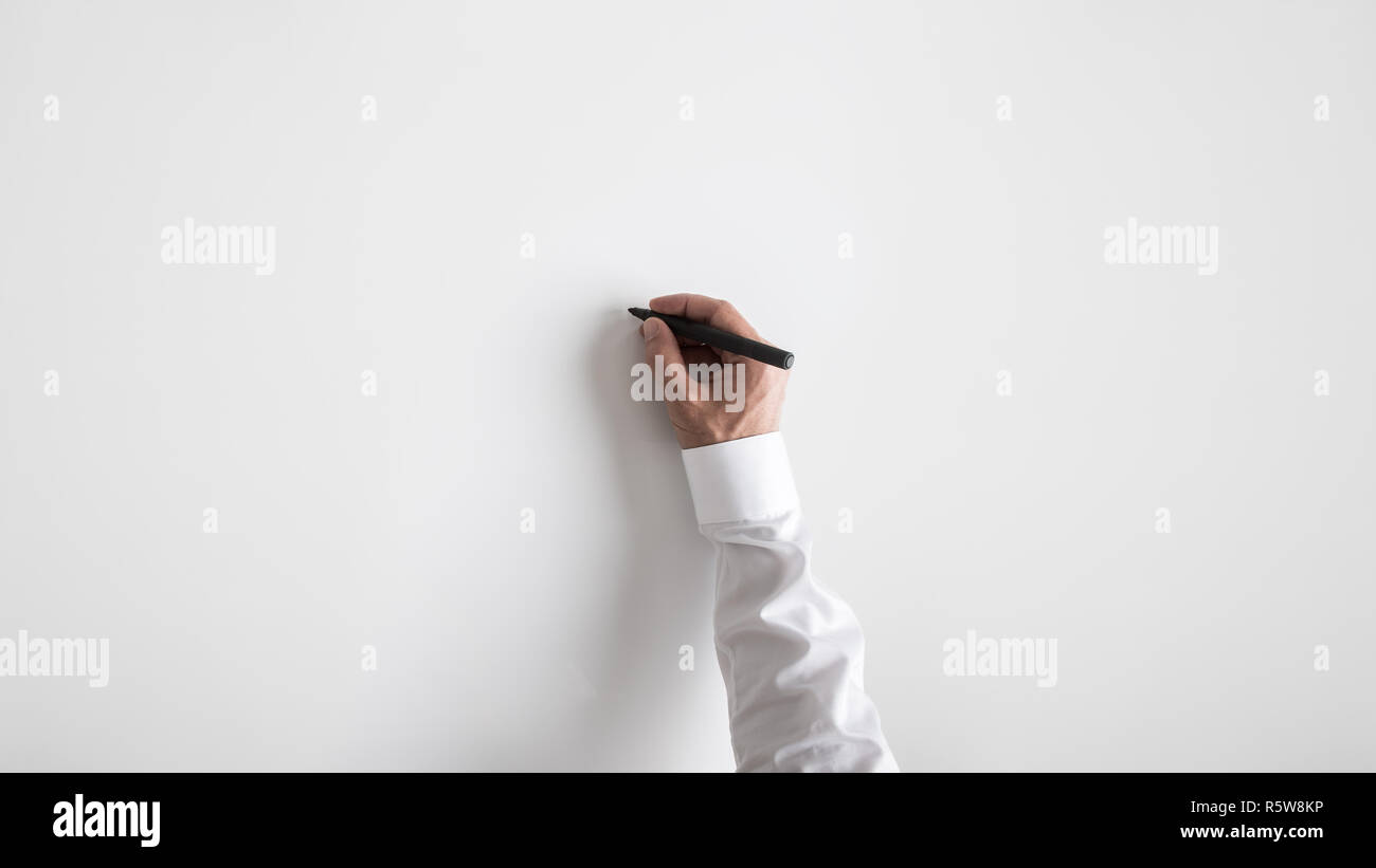 Male hand writing on white background with black marker. With plenty of ...