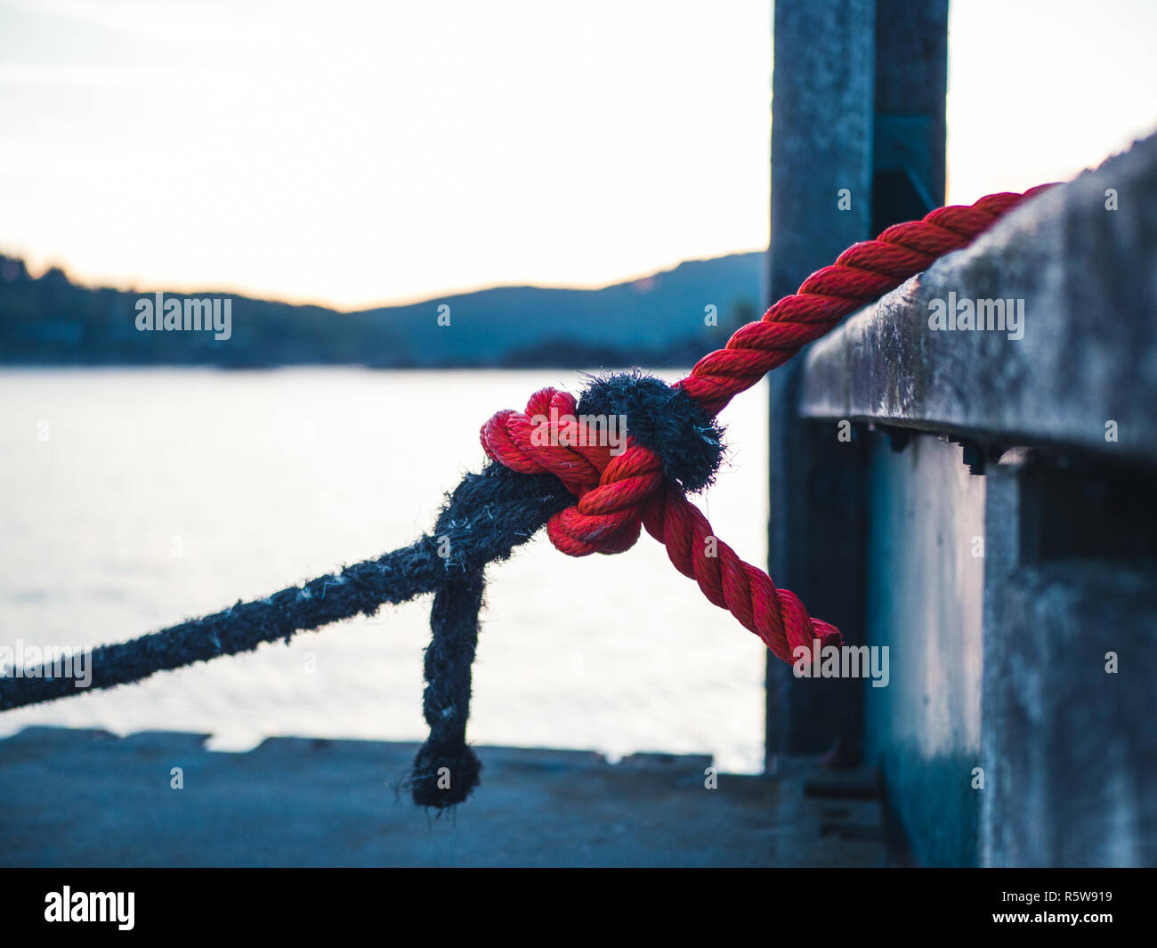 Two different colored ropes tied together at a mooring Stock Photo - Alamy