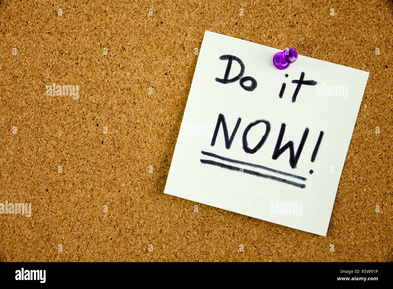 A reminder to do it now message, Bulletin board with a blue sticky note ...