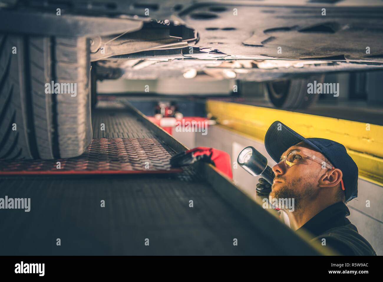 Car Suspension Issue. Caucasian Vehicle Mechanic with Flashlight ...