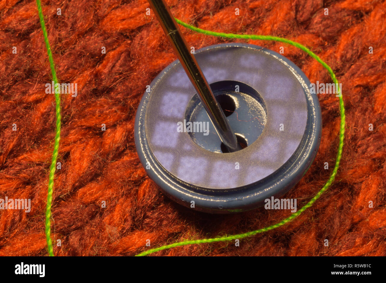 Button and needle with thread on textile background Stock Photo - Alamy