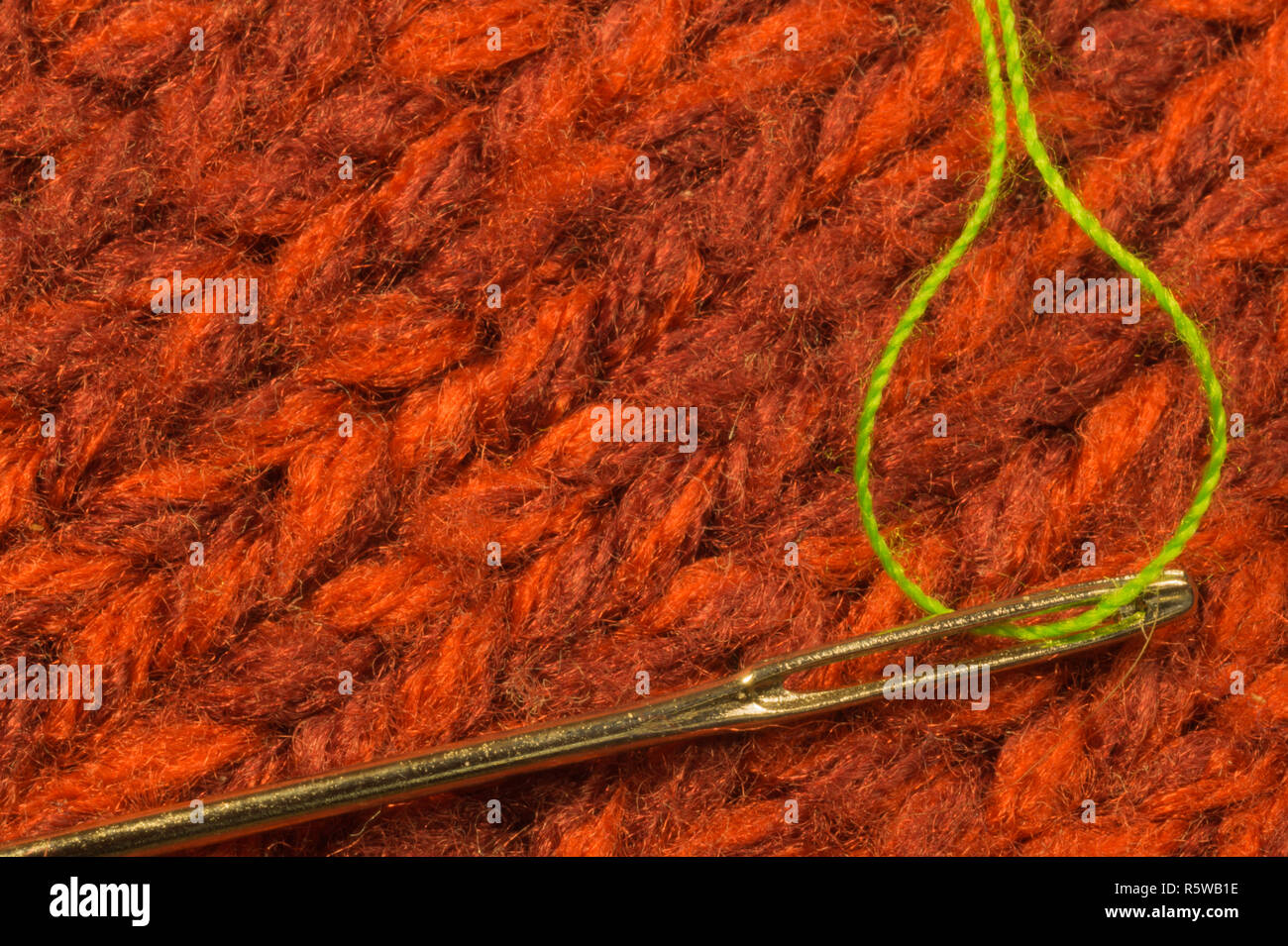 Needle with thread macro on textile background Stock Photo - Alamy