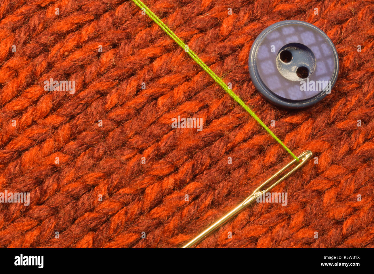 Button and needle with thread on textile background Stock Photo - Alamy