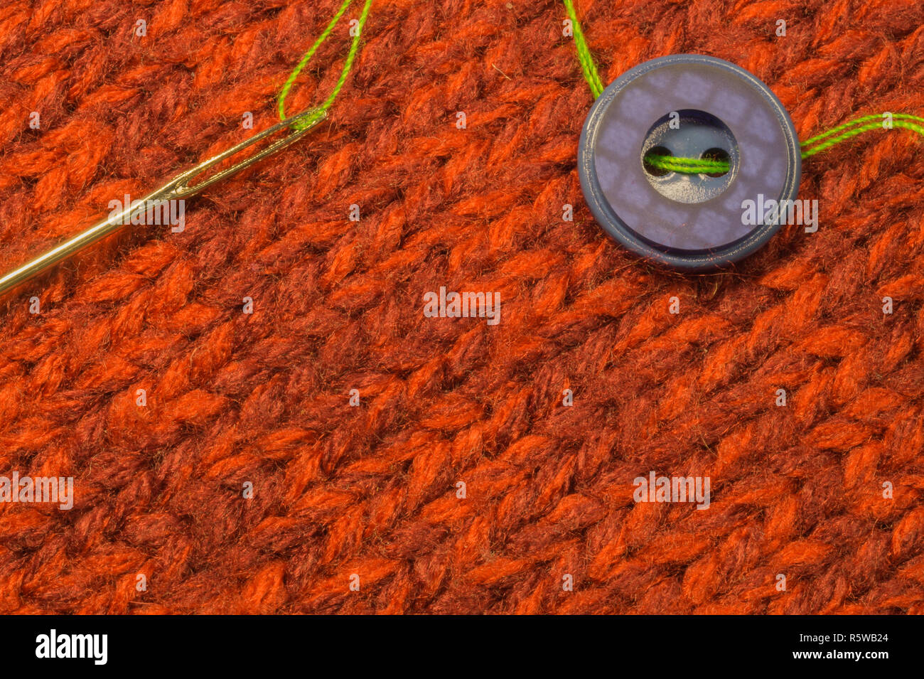Button and needle with thread on textile background Stock Photo - Alamy