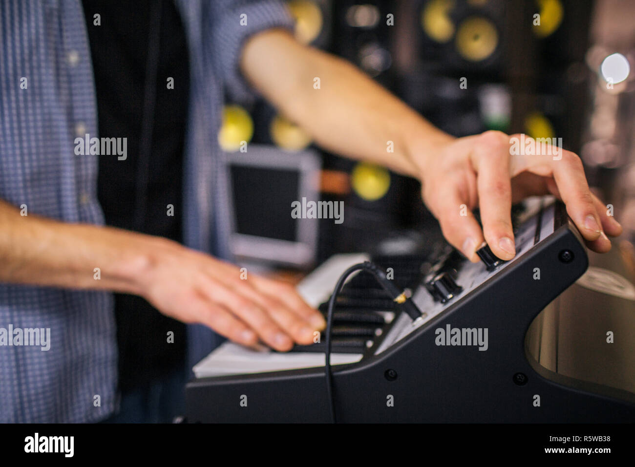 Close up of man's hands on keyboard. Guy turn sound on. He stand in ...