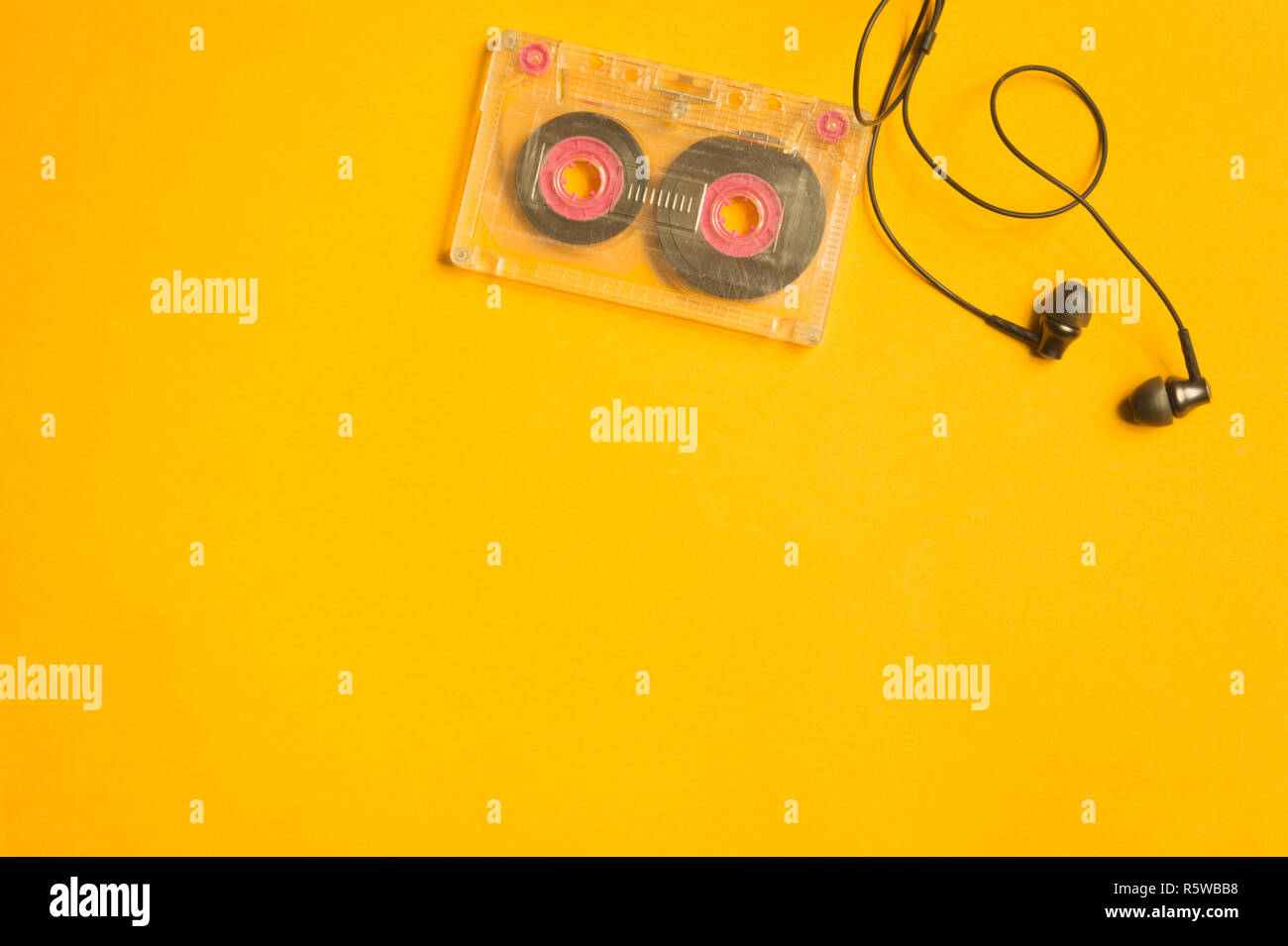 Headphones and retro cassette on yellow background Stock Photo - Alamy