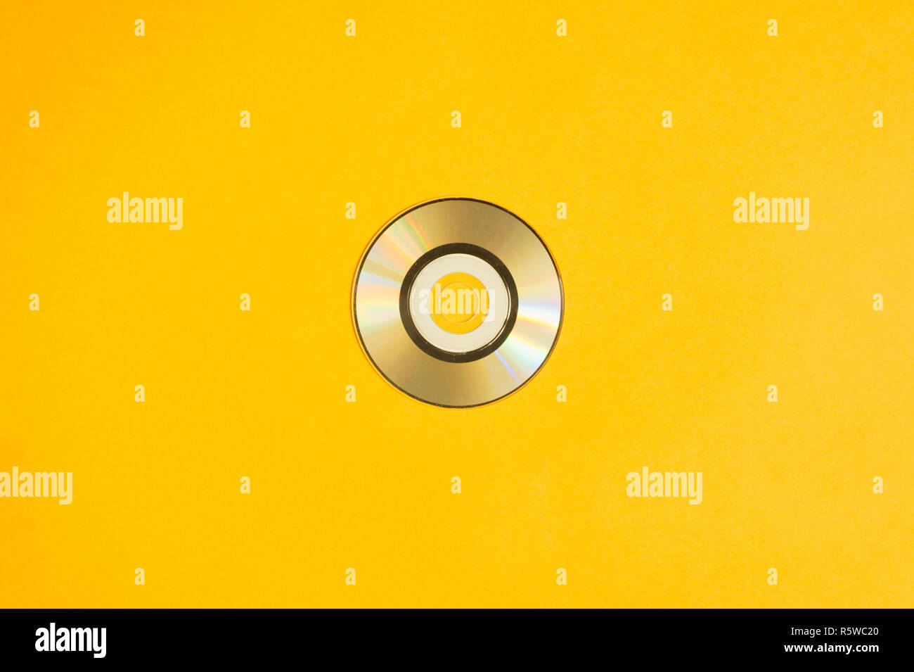 Mini compact disc on yellow background Stock Photo - Alamy