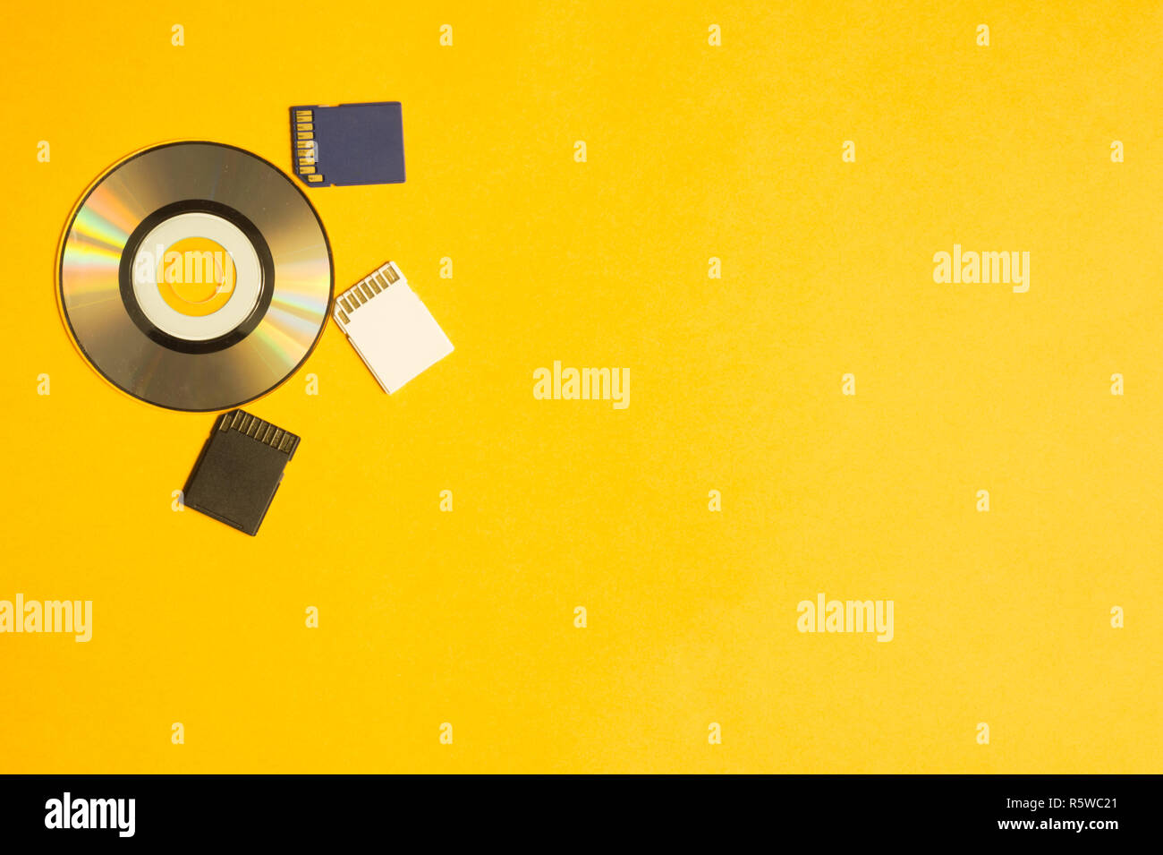 Memory card and digital disc isolated on yellow background. copy space ...