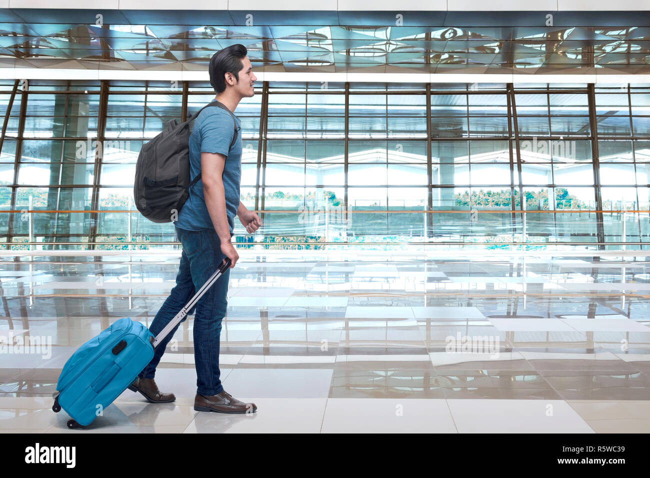 Young asian man walking and pulling the suitcase Stock Photo - Alamy