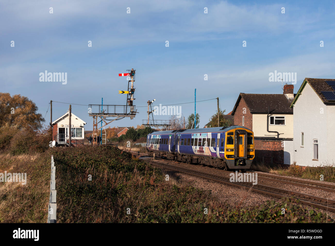 Arriva Northern rail class 158 sprinter train passing the mechanical signal box & semaphore ...