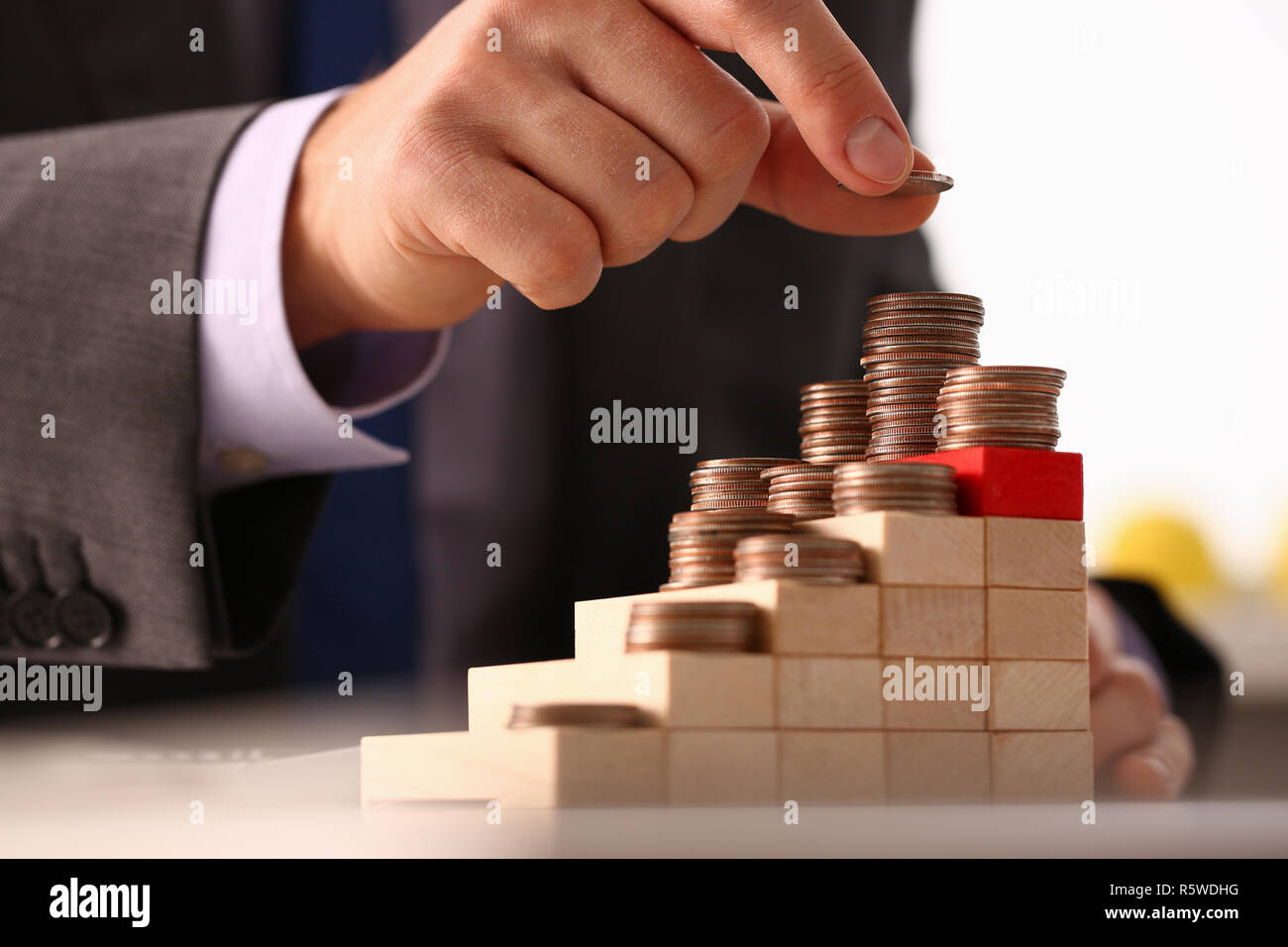 Hand businessman putting pin money Stock Photo - Alamy