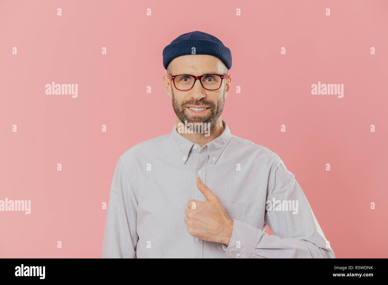 Satisfied attractive man has appealing look, raises thumb, agrees with ...