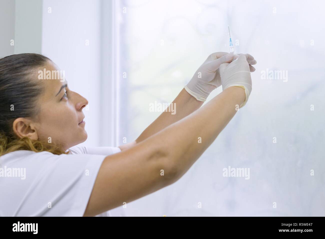 Nurse holding a syringe with vaccine, prepares for an injection ...