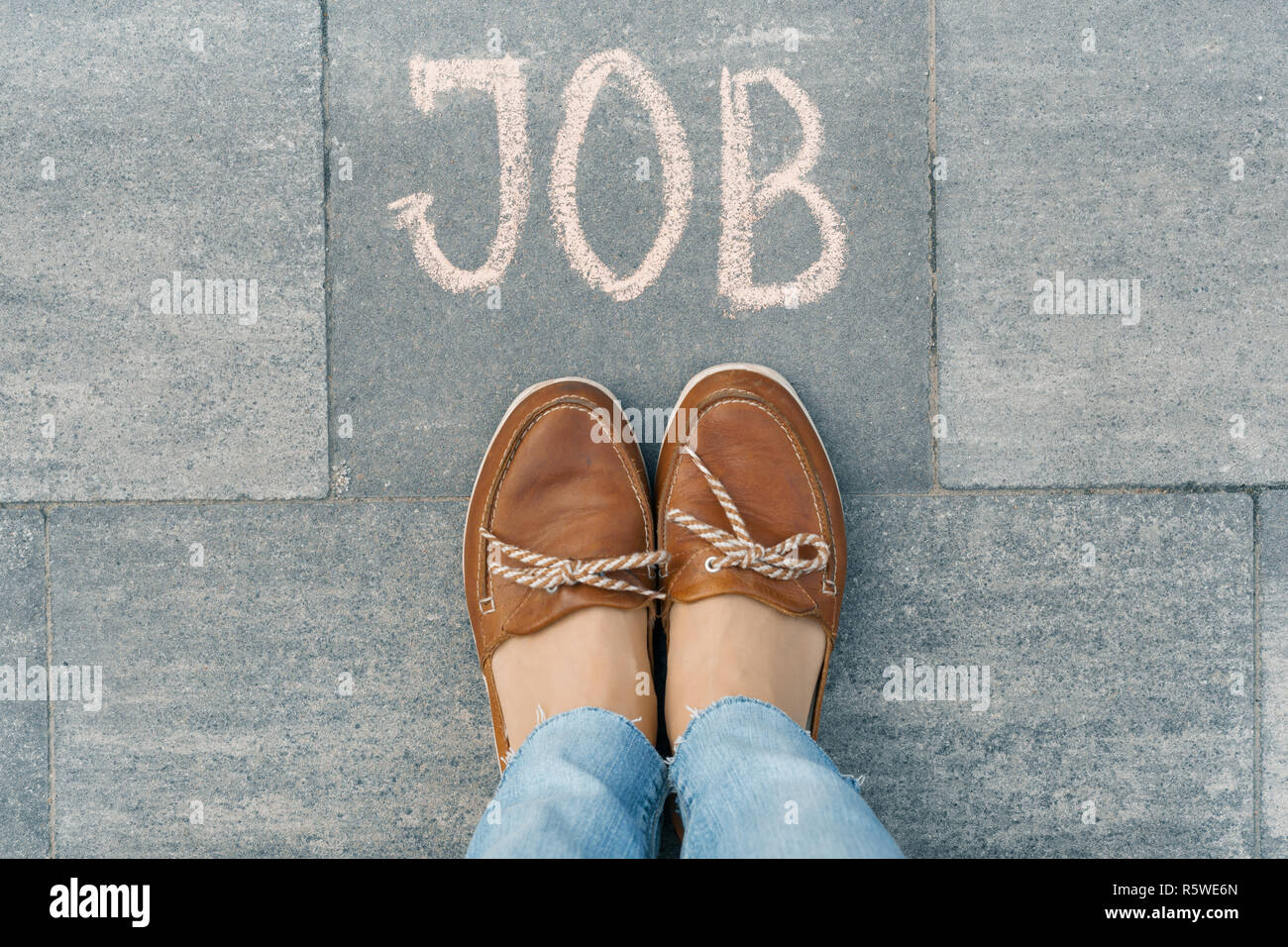 Female feet with text job written on grey sidewalk Stock Photo - Alamy