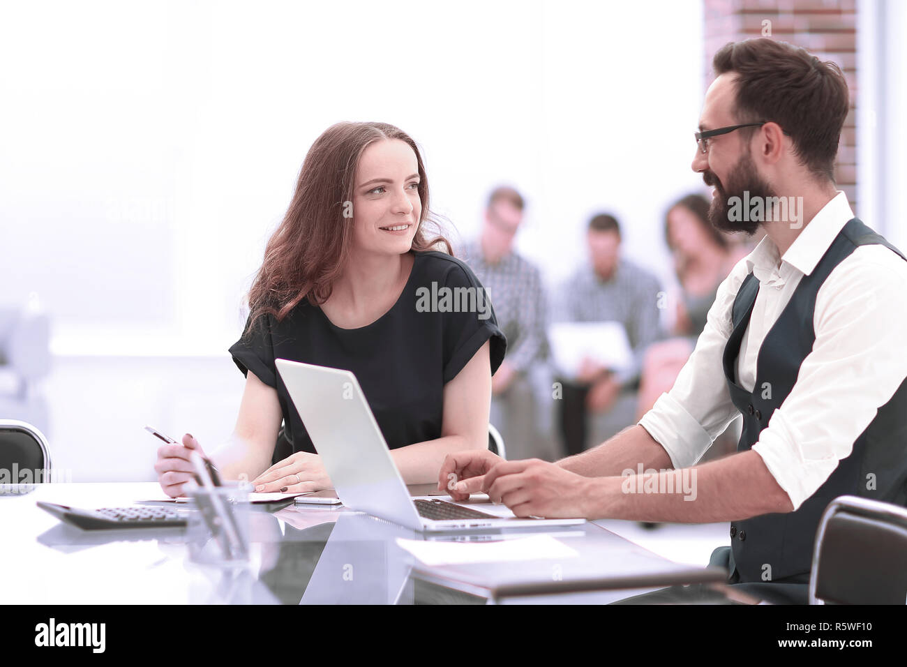 two employees sitting at a Desk in the office Stock Photo - Alamy