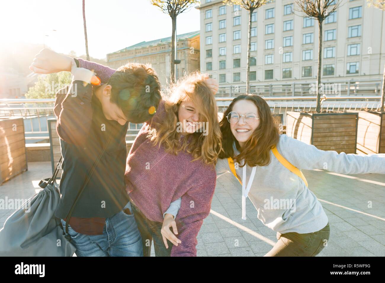 Friends teenagers students with school bags, having fun on the way from ...