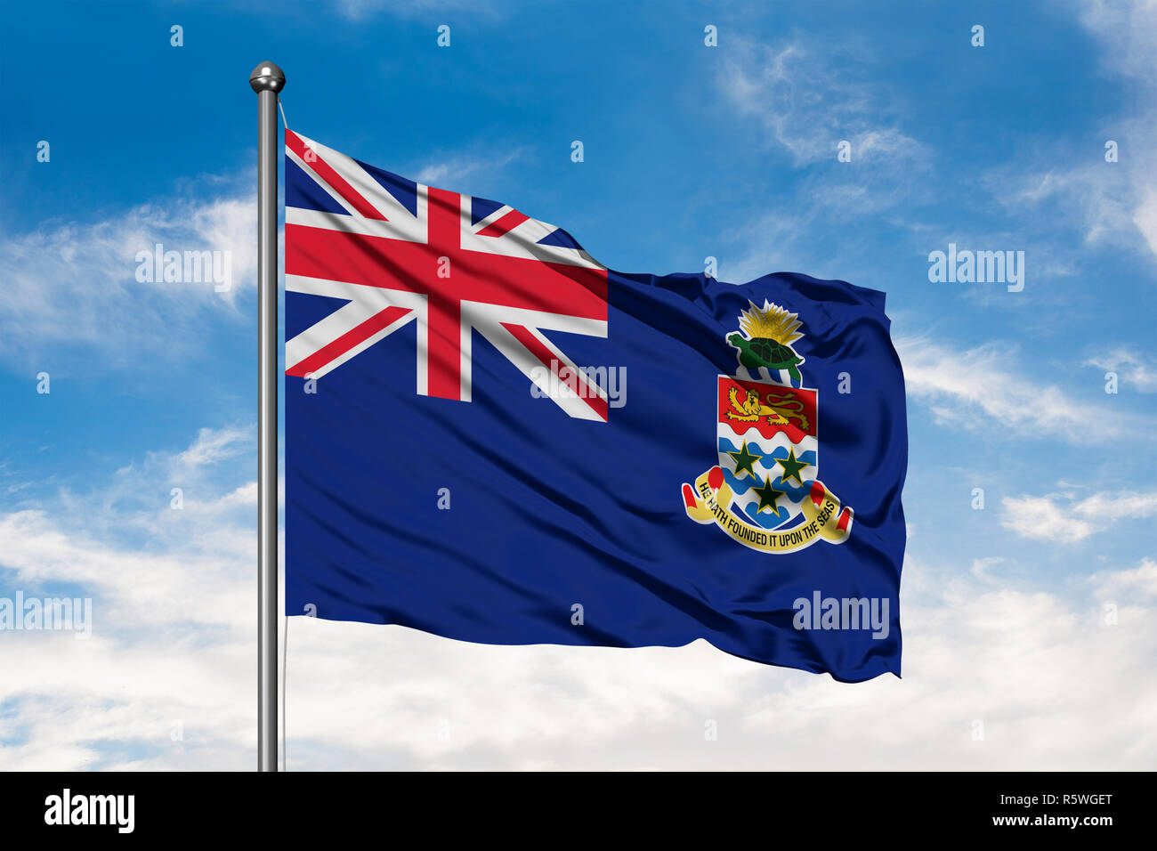 Flag of Cayman Islands waving in the wind against white cloudy blue sky ...