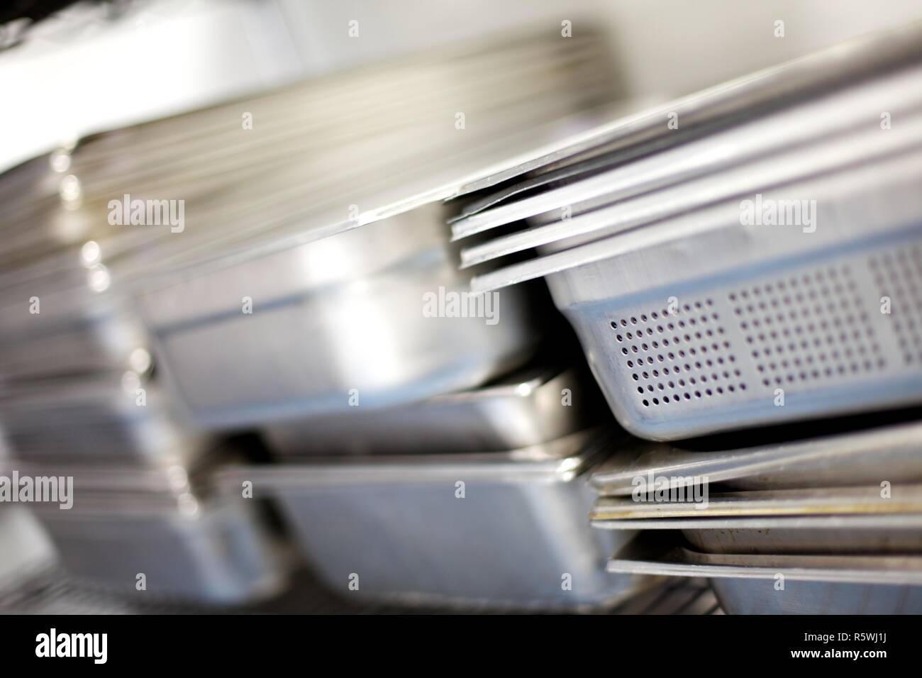 stacks of stainless steel catering trays in a commercial kitchen Stock ...