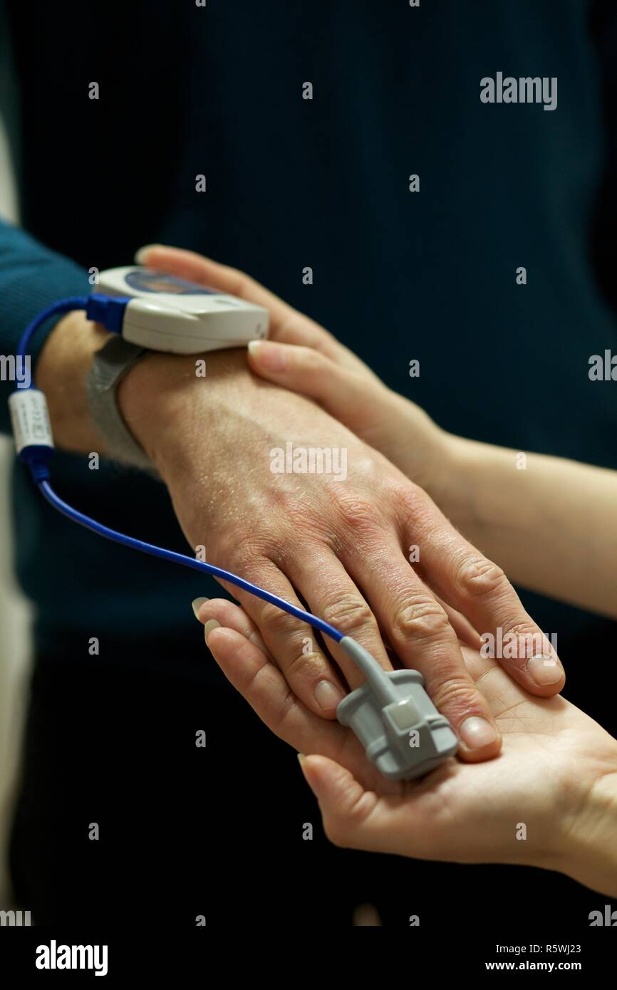 A nurse uses a pulse oximeter to monitor a patients oxygen saturation ...