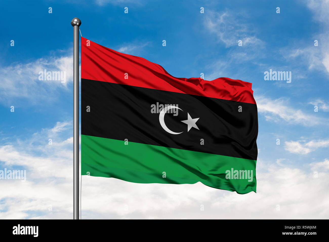 Flag of Libya waving in the wind against white cloudy blue sky. Libyan ...