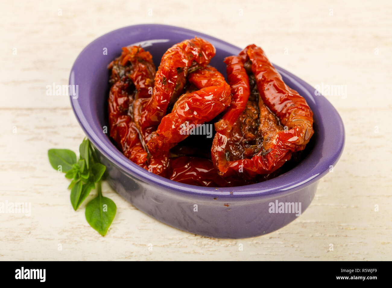 Dried tomato in olive oil with basil leaves Stock Photo - Alamy