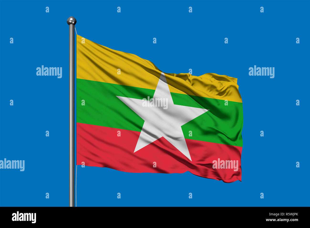 Flag of Myanmar waving in the wind against deep blue sky. Burma flag ...