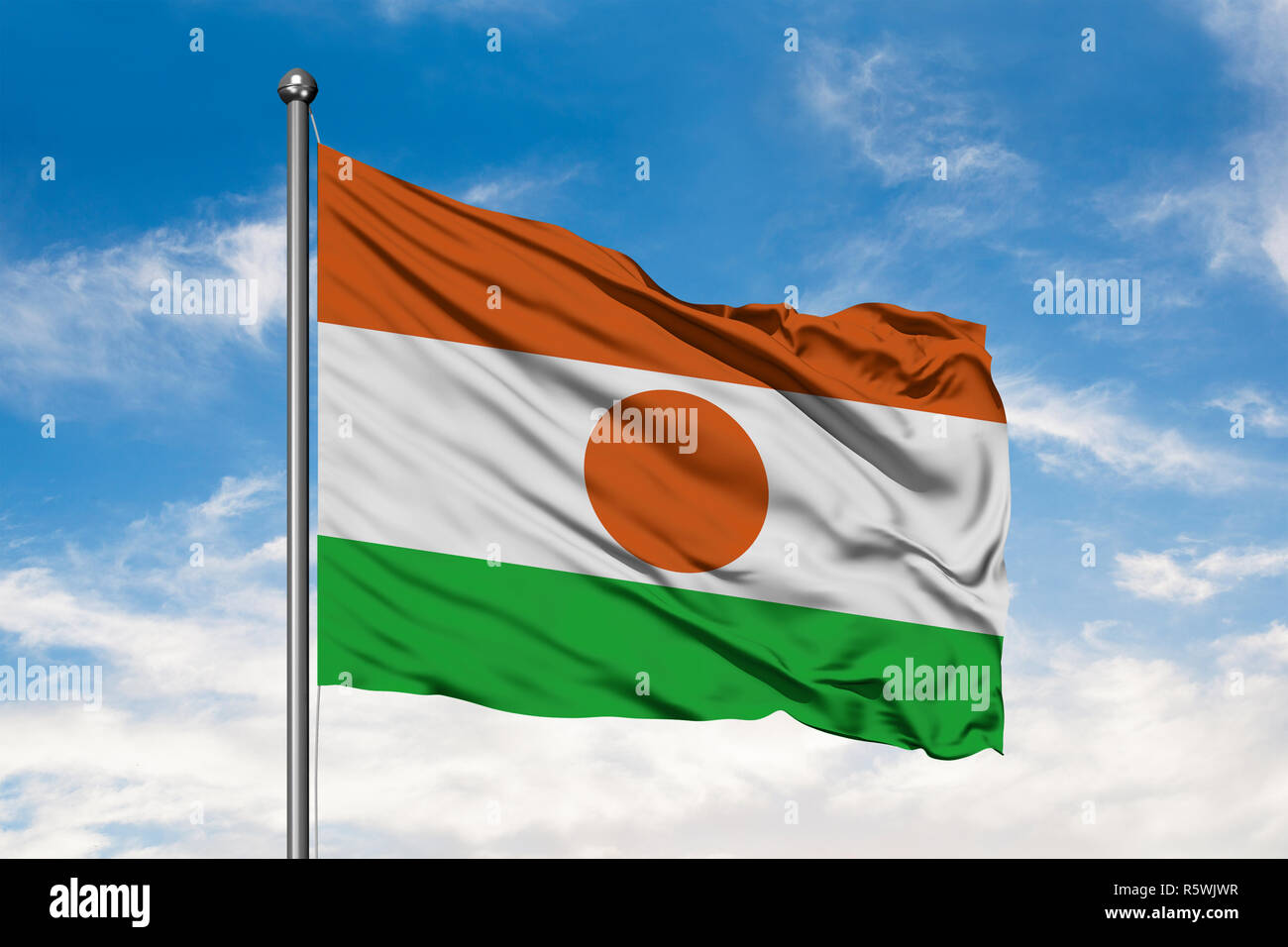 Flag of Niger waving in the wind against white cloudy blue sky ...