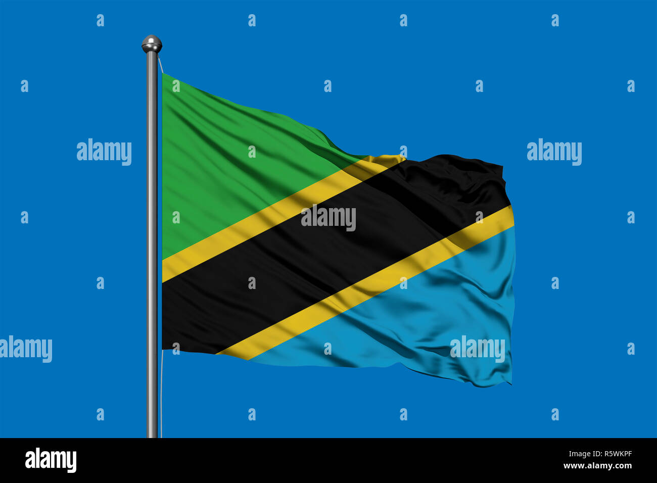 Flag of Tanzania waving in the wind against deep blue sky. Tanzanian ...