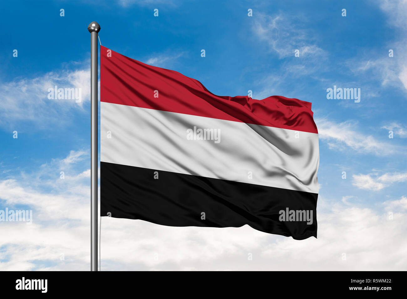 Flag of Yemen waving in the wind against white cloudy blue sky. Yemeni ...
