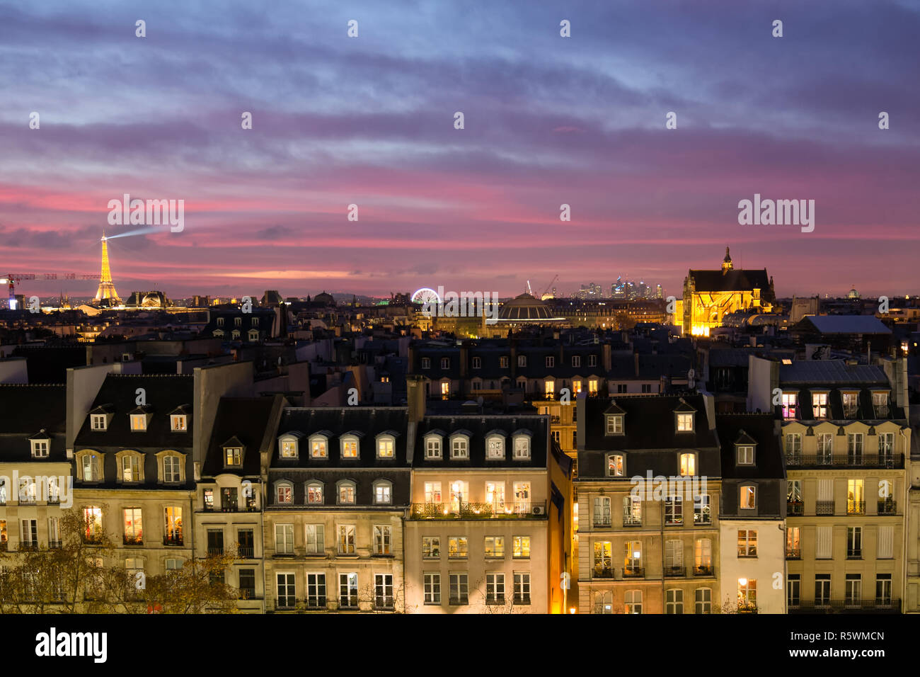 View of Paris with classic architecture in evening with glowing windows ...