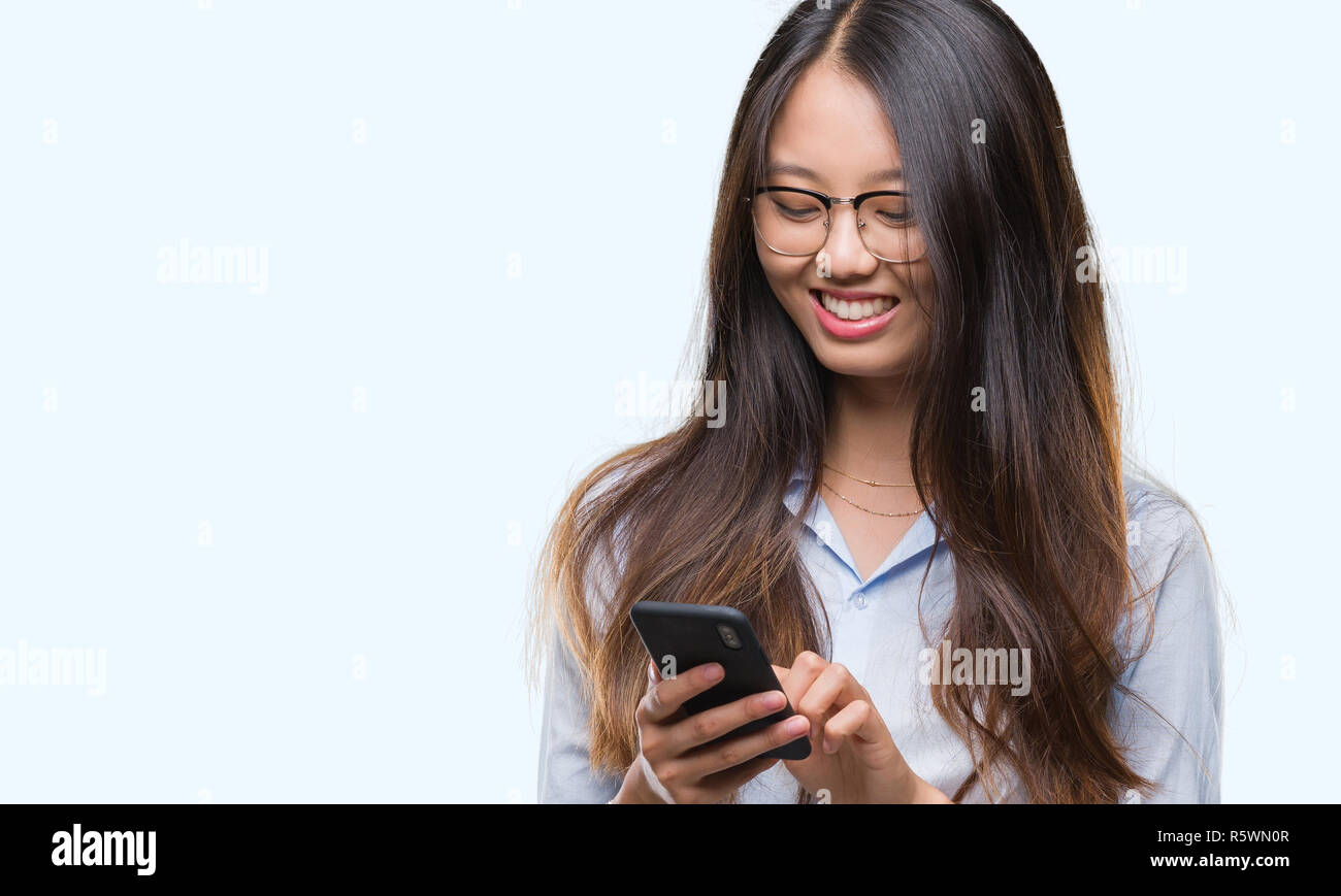 Young asian woman texting using smartphone over isolated background ...