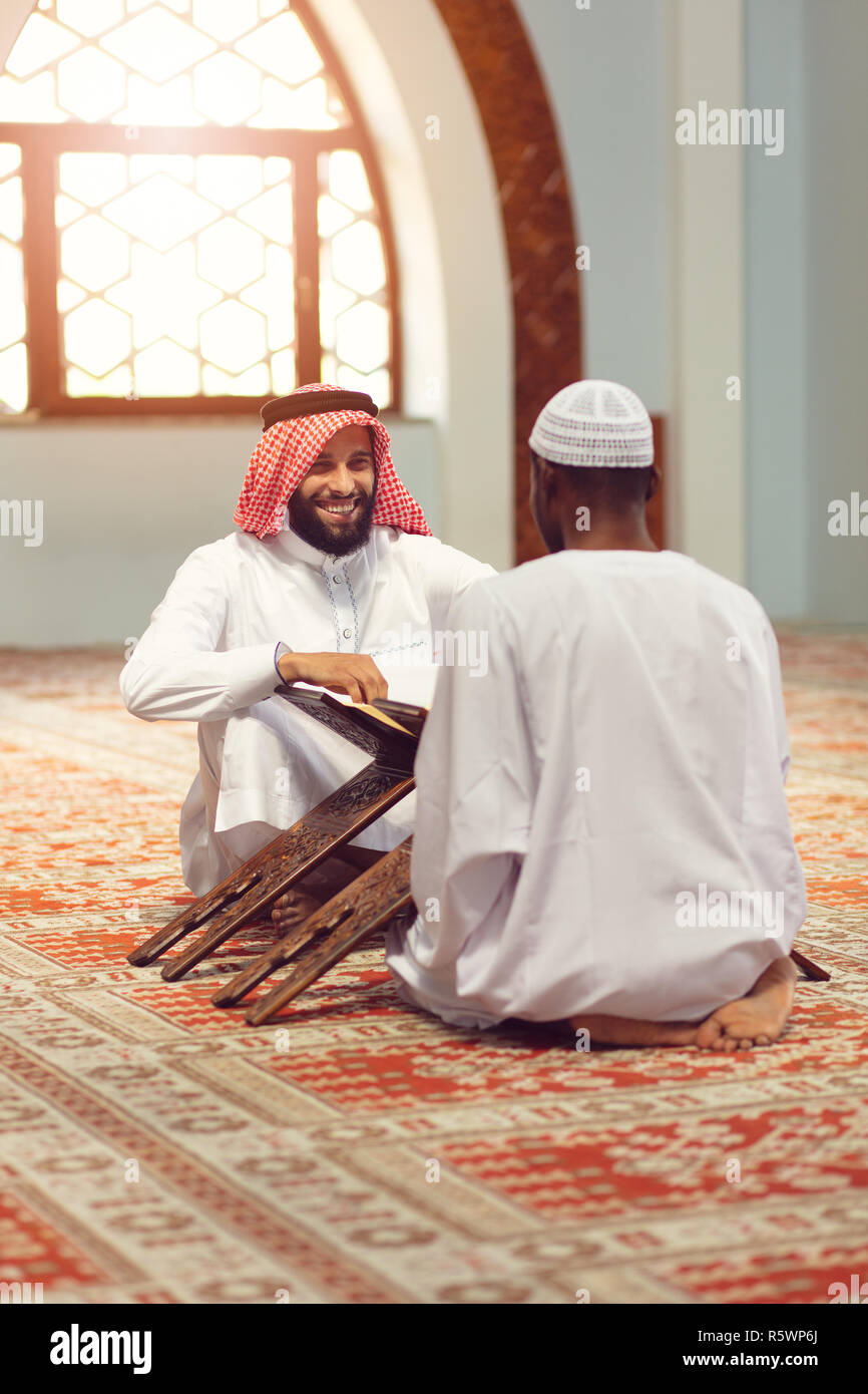 Muslim men praying with holy books in mosque Stock Photo - Alamy