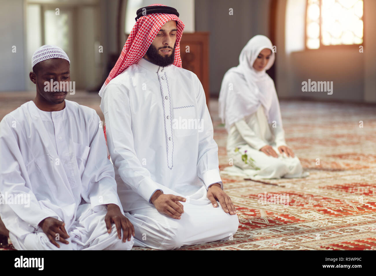 Muslim men praying with holy books in mosque Stock Photo - Alamy