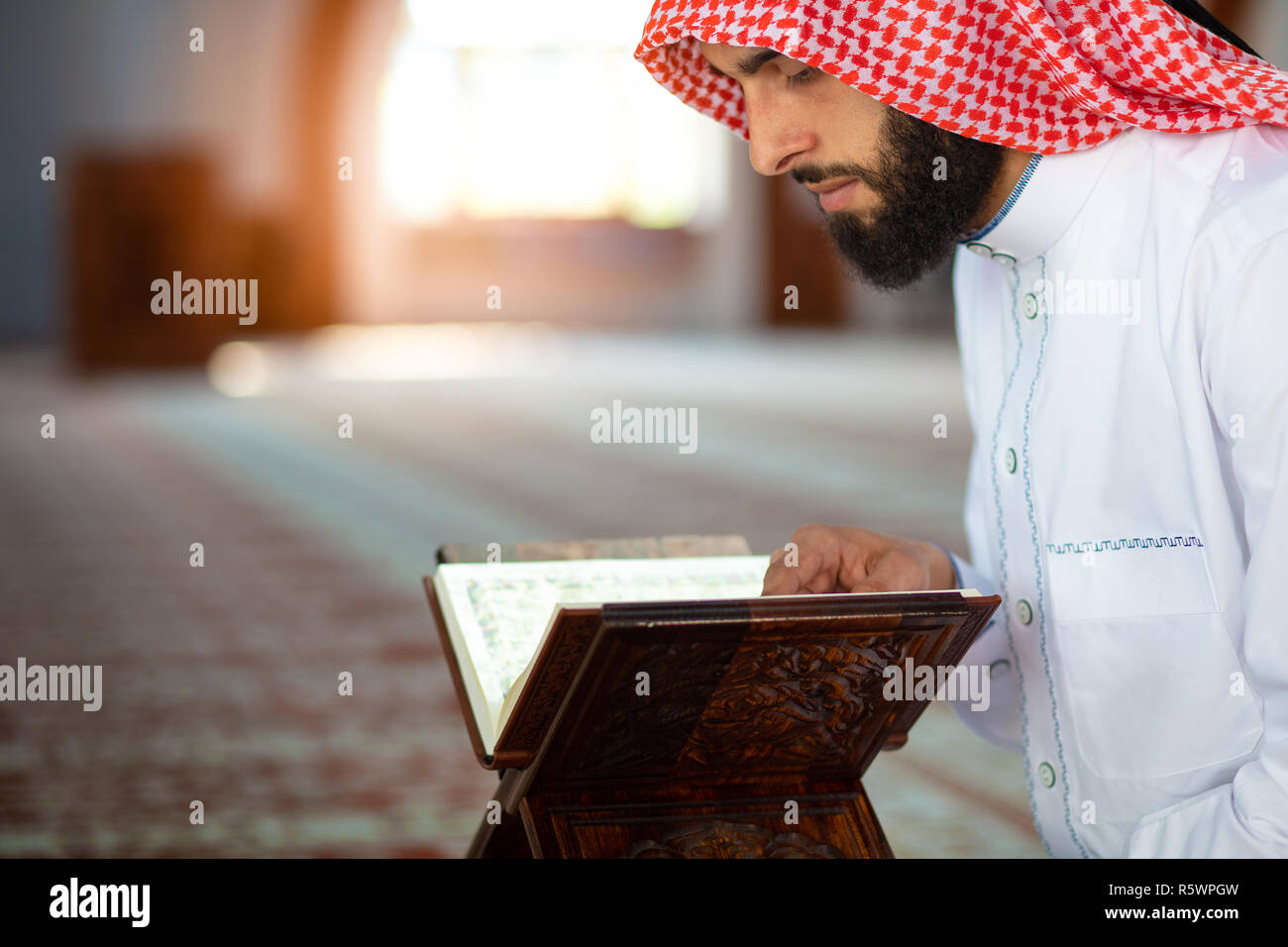 Ethnic man reading Koran and praying in mosque Stock Photo - Alamy