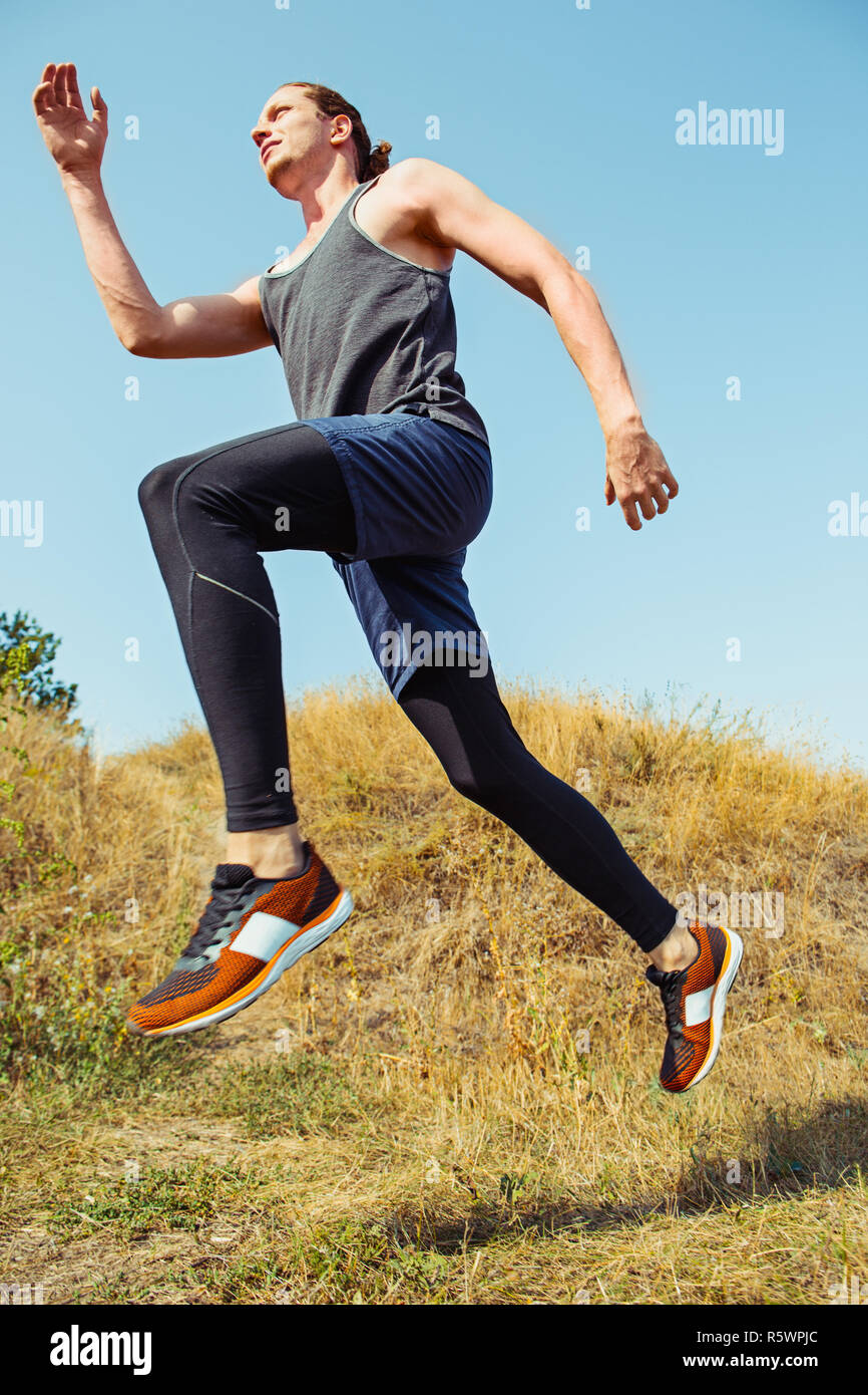Running sport. Man runner sprinting outdoor in scenic nature. Fit ...