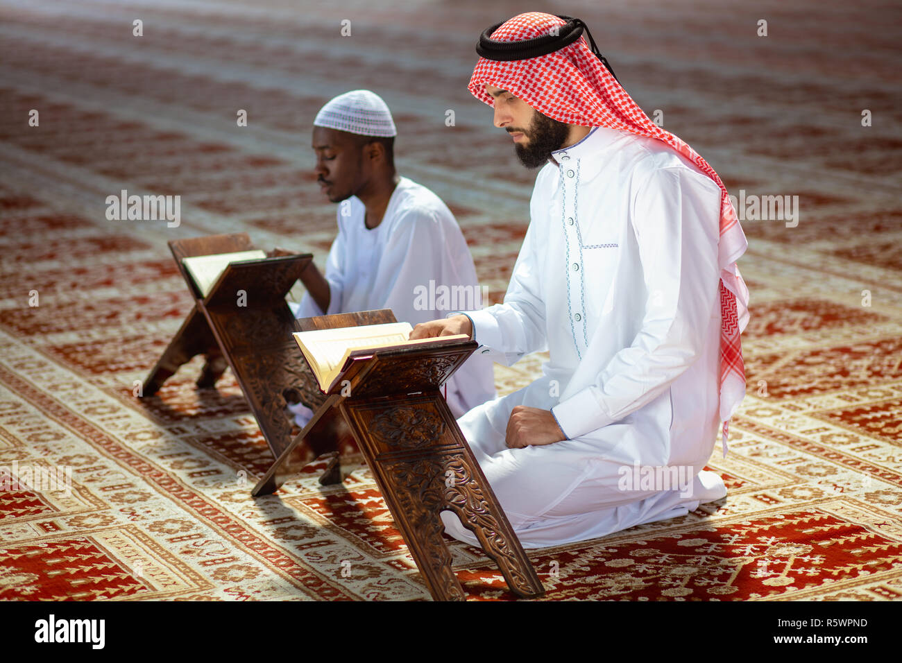 Muslim men praying with holy books in mosque Stock Photo - Alamy