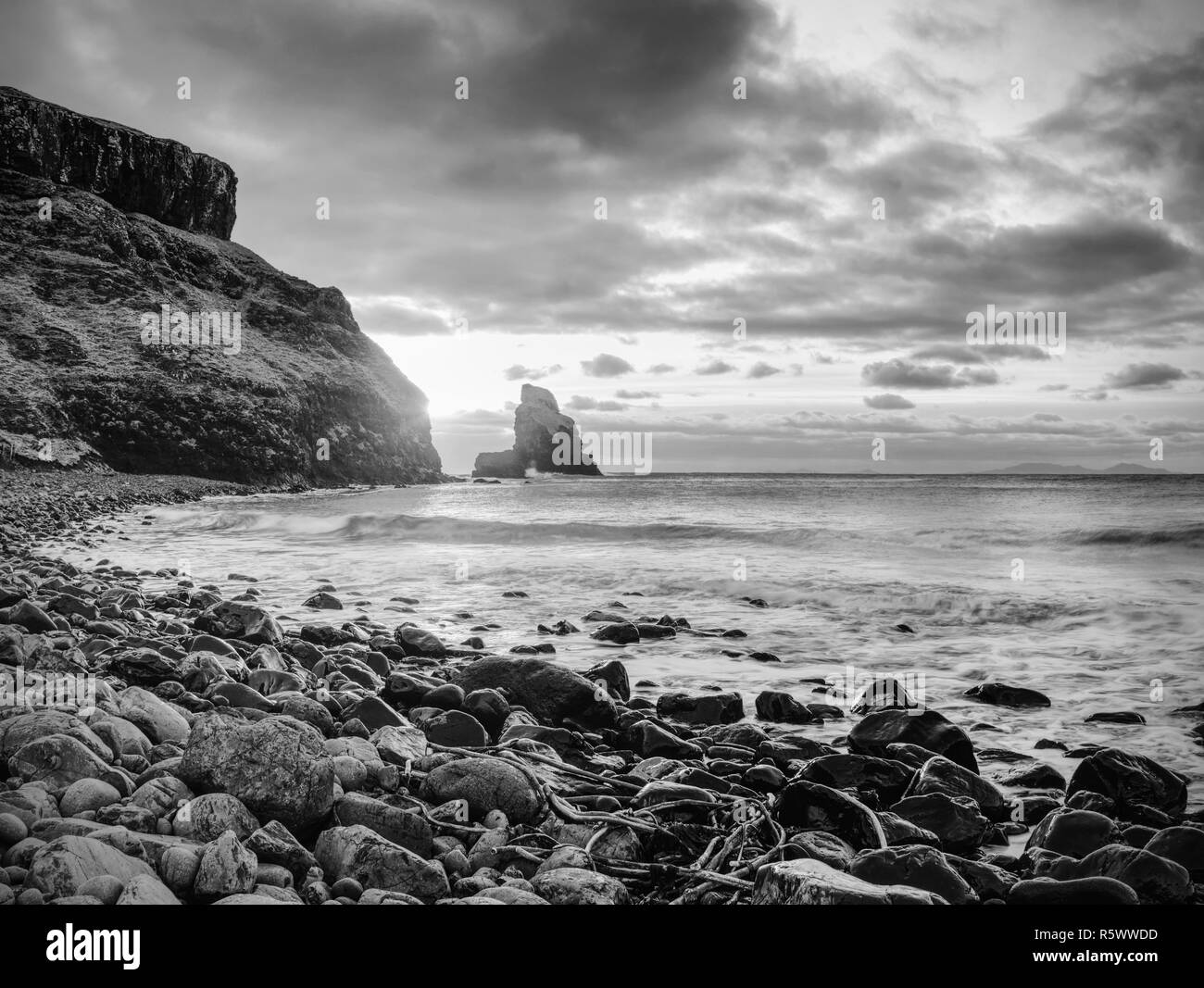 Evening Bay. Sharp rocks, black rounded boulders, stony beach, sand and ...